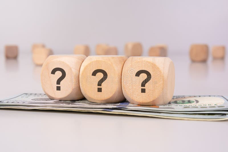Three Wooden Blocks with Question Marks on Dollar Bills, Symbolizing ...