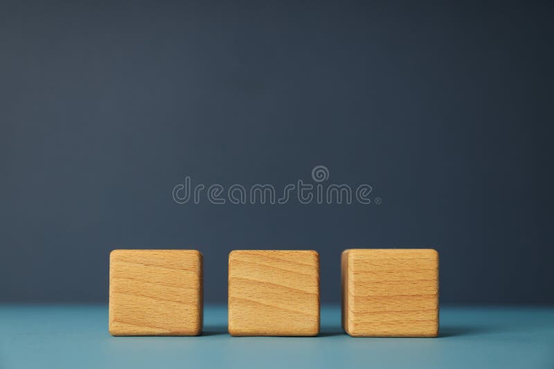 Three Wooden Cubes on Blue Table, Space for Text Stock Photo - Image of ...