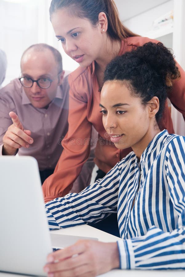 Three Colleagues Looking at a Computer Stock Image - Image of documents ...