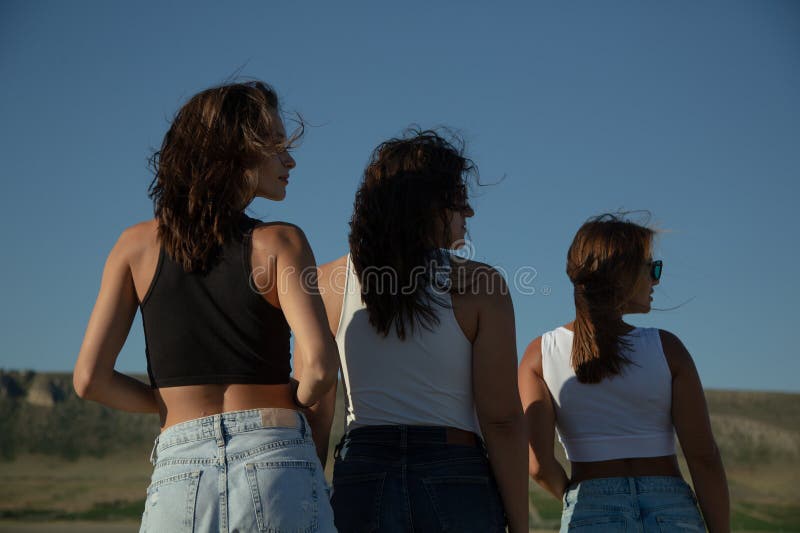 Three Young Attractive Women Stand with Their Backs Turned and Their ...