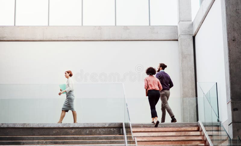 Young Businesspeople at Work, Walking Up the Stairs. Stock Photo ...