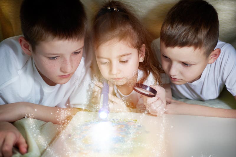 Three Children are Looking into a Book only Stock Image - Image of ...