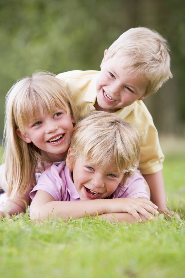 Three Young Children Playing Outdoors Smiling Stock Image - Image of ...
