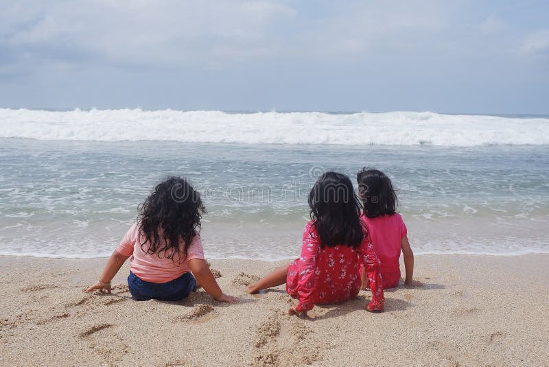 Just Take Photo a Three Young Children Sit on a Sandy Beach, Facing the ...