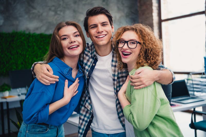 Three Young Colleagues Smiling in a Modern Office, Symbolizing Teamwork ...