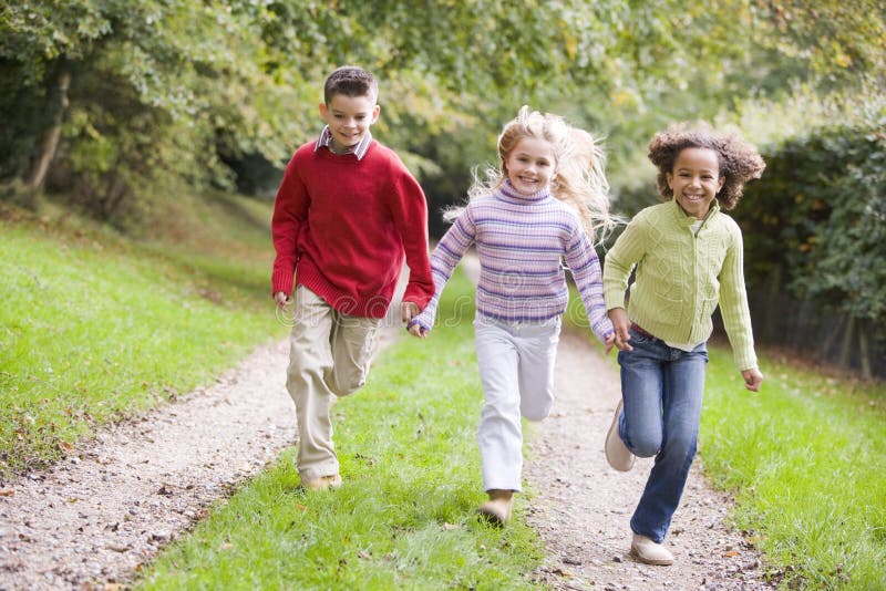 Three Young Friends Running on a Path Outdoors Stock Photo - Image of ...