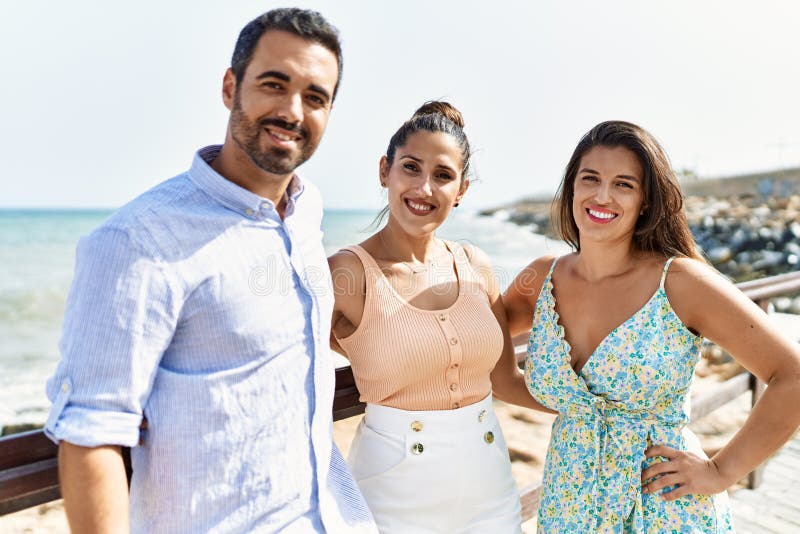 Three Young Hispanic Friends Smiling Happy and Hugging at the Beach ...