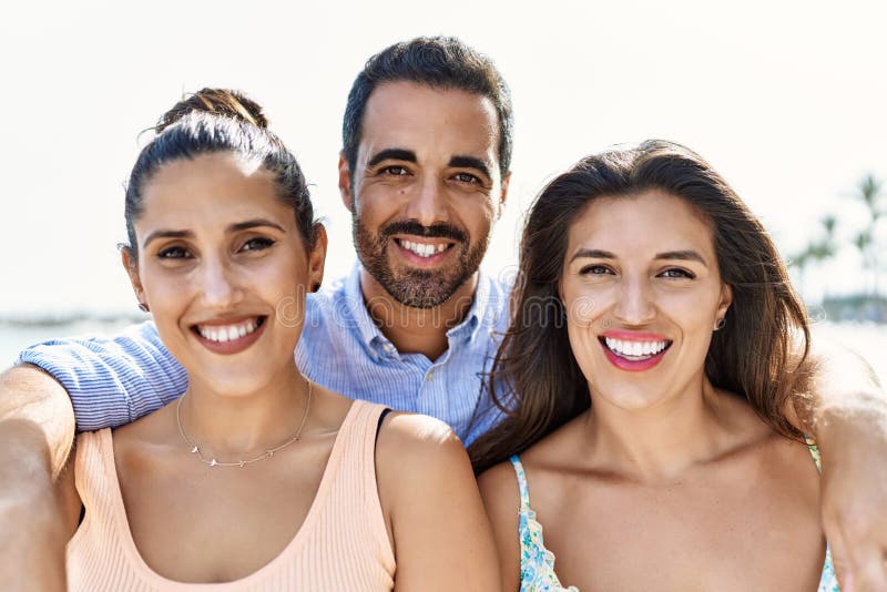 Three Young Hispanic Friends Smiling Happy and Hugging at the Beach ...