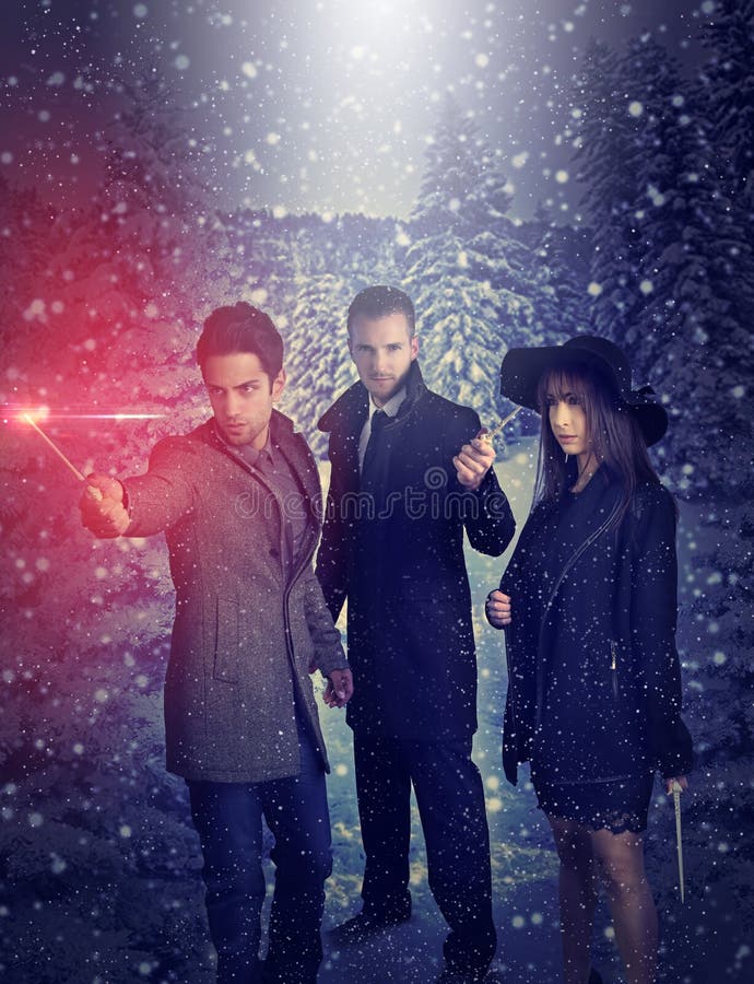 Three Young Magicians Holding a Magic Wand during a Snowy Night Stock ...