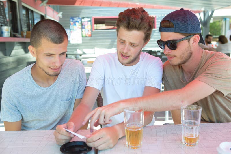 Three young men in bar stock image. Image of holiday - 93765815
