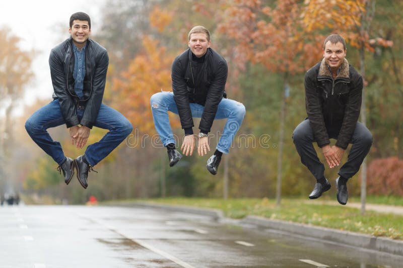 Three Young Men in Black Jackets Jumping for Joke Stock Image - Image ...