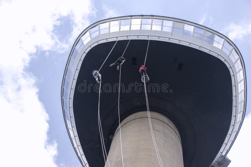 Three Young People Abseiling Down the Euromast Tower in Rotterdam Stock ...