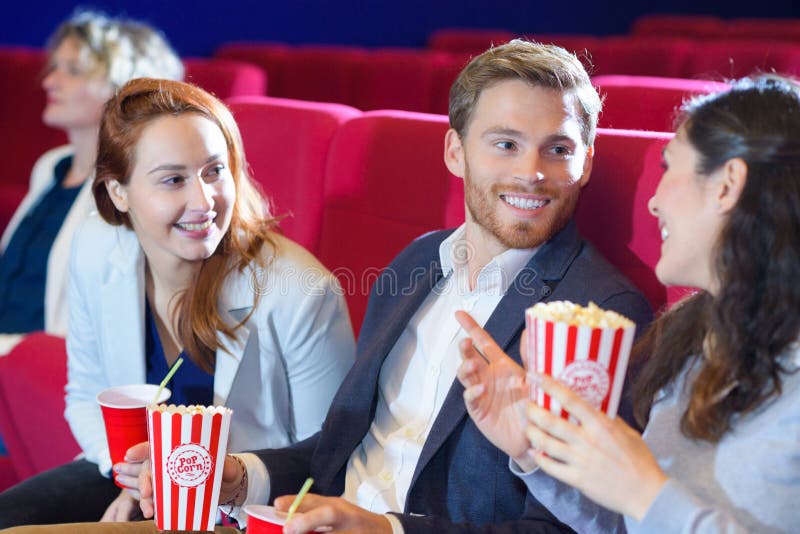 Three Young People Chatting in Cinema Seats Stock Image - Image of ...