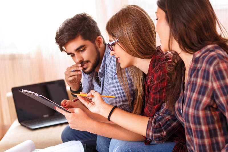 Three Young Students Working Together on a New Project. Stock Image ...
