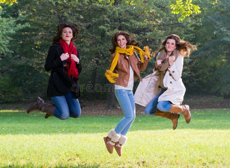 Three Young Women Jumping Joyfully in the Park Stock Image - Image of ...