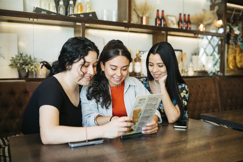 Three Women Looking at a Menu in a Restaurant Stock Image - Image of ...