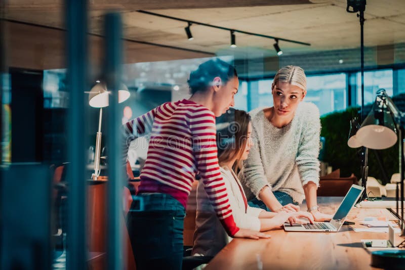 Three Young Women in a Modern Office Solve a Problem Together while ... Three Young Women in a Modern Office Solve a Problem Together while ...