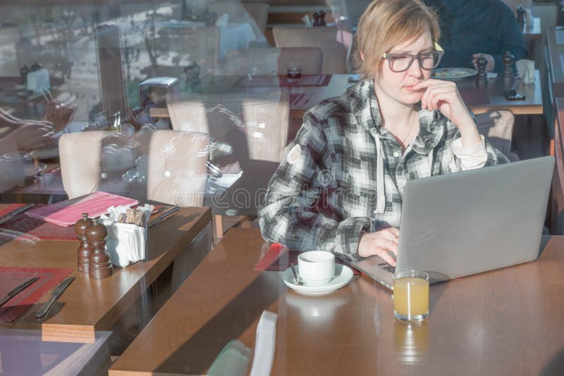 Throw Window Image of Woman Working on Computer at Restaurant Stock ...
