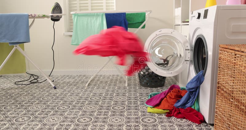 Happy Causasian Teen Boy Throwing Dirty Clothes into Washing Machine As ...