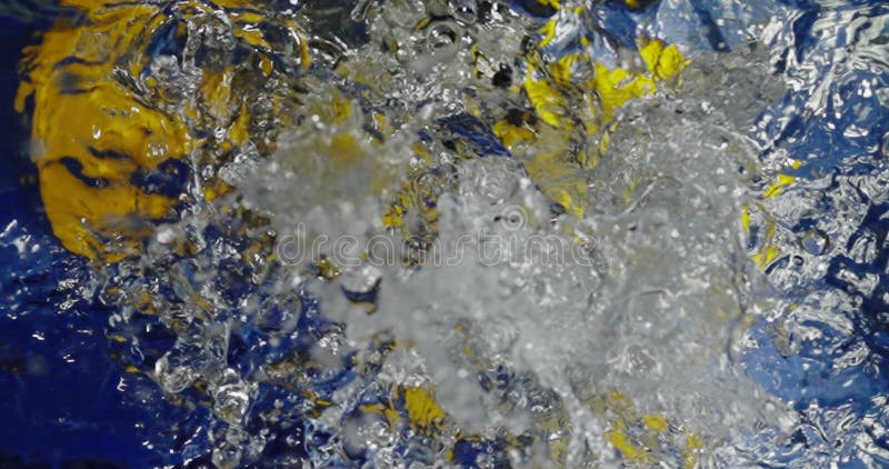 Throwing Lemons into Water on a Blue Background. Splashes Spilling in ...
