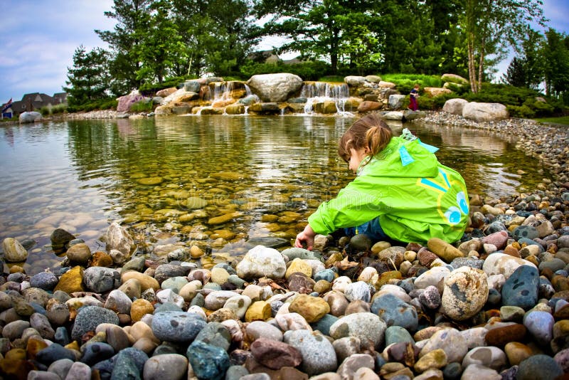 Child throwing rocks stock photo. Image of pretty, pond - 7317212
