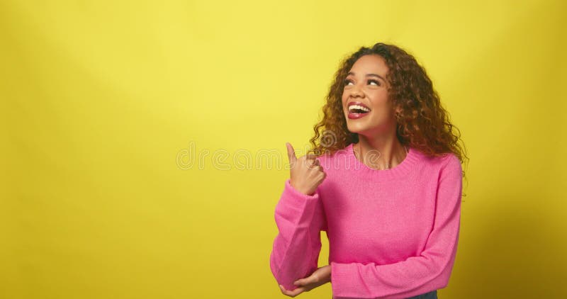 Thumb Pointing Back at Copy Space, Beautiful Multi-ethnic Woman, Yellow ...