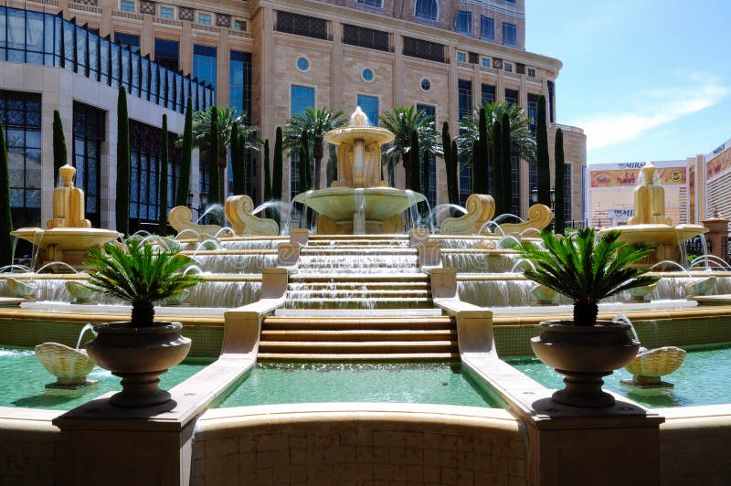 Tiered Fountain with Water, Palm Trees, Classical Architecture on Sunny ...
