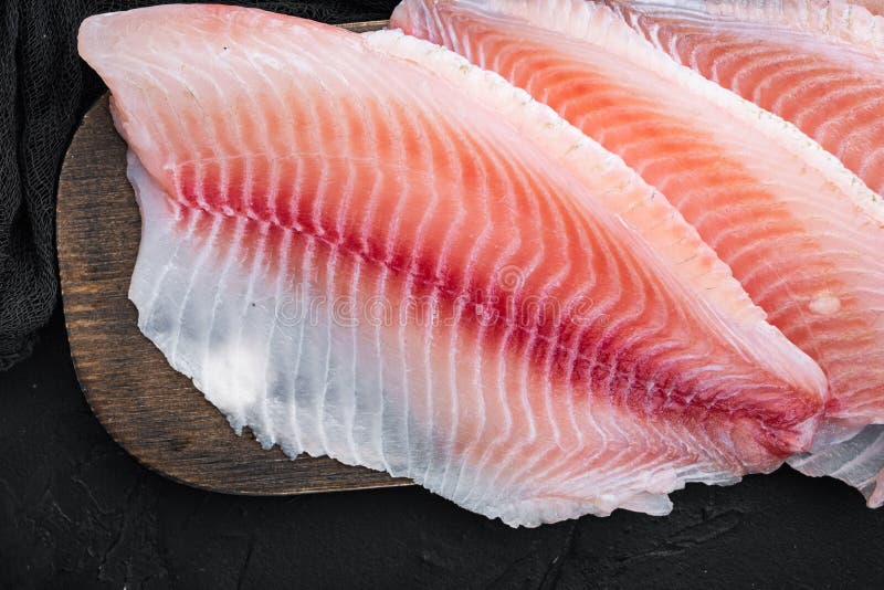 Tilapia Fish Fillet Meat, on Black Background, Top View Stock Photo ...