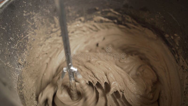 Tile Adhesive is Mixed in a Bucket. Adhesive Mix for Tiles in a Black ...