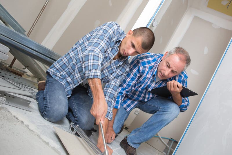 Tile Cutting Apprentice and Manager Working with Floor Tile Cutting ...