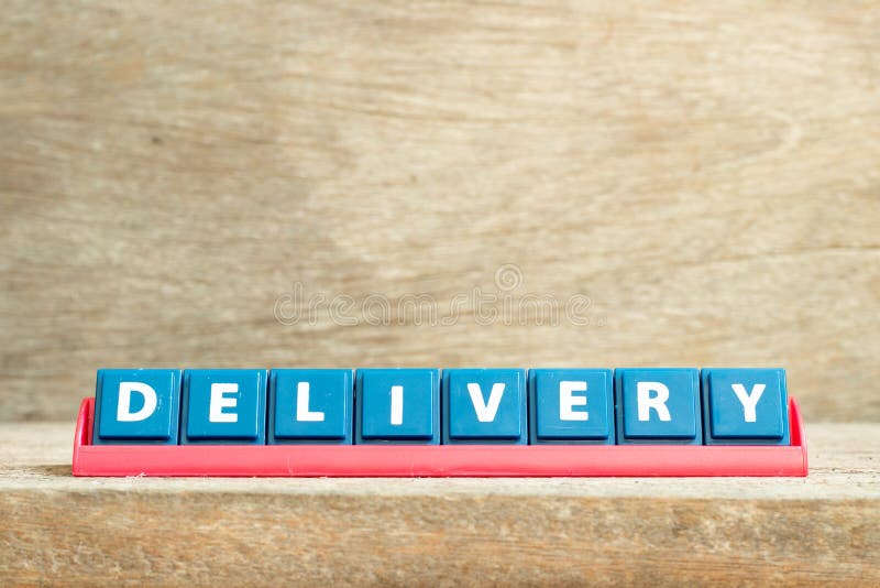 Word DELIVERY Made from Wooden Cubes on Yellow Background with Toys ...