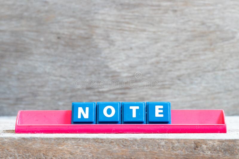Tile Letter on Rack in Word Note on Wood Background Stock Photo - Image ...