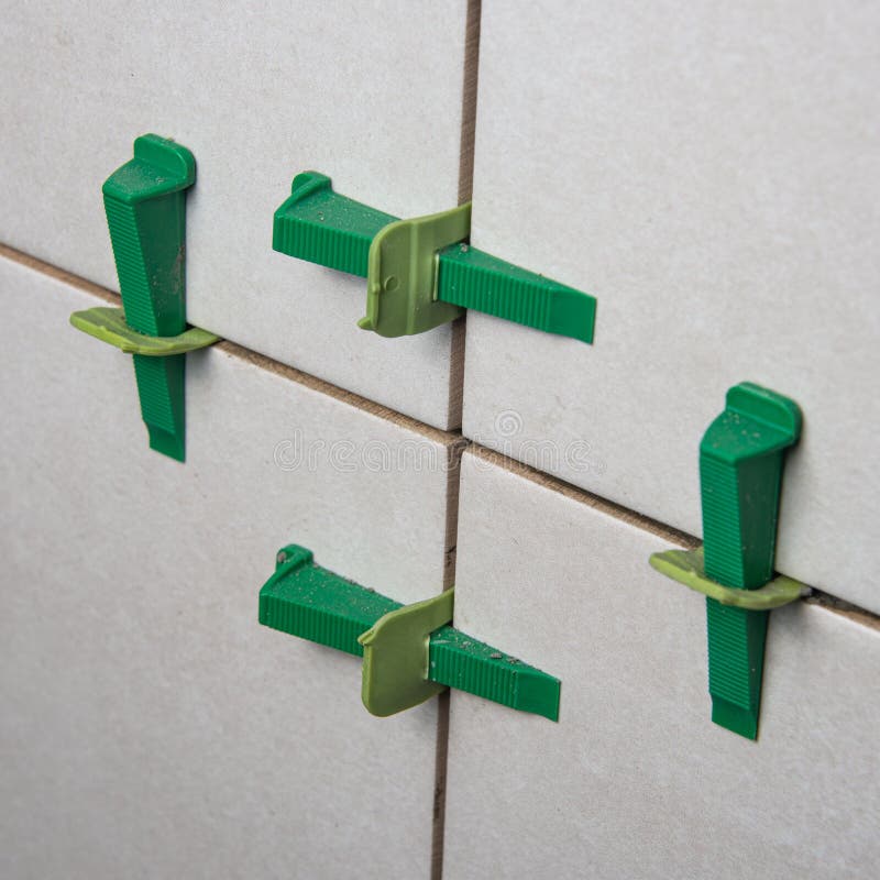 Tile Leveling System with Plastic Clips and Wedges, Shot while the Tile ...