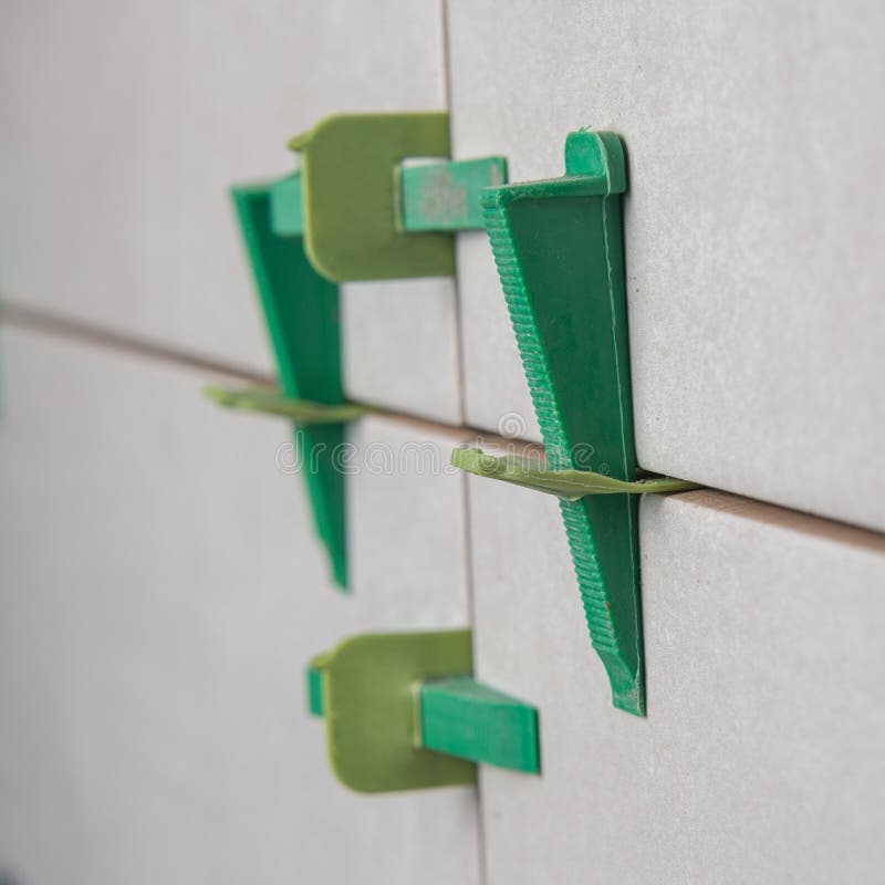 Tile Leveling System with Plastic Clips and Wedges, Shot while the Tile ...