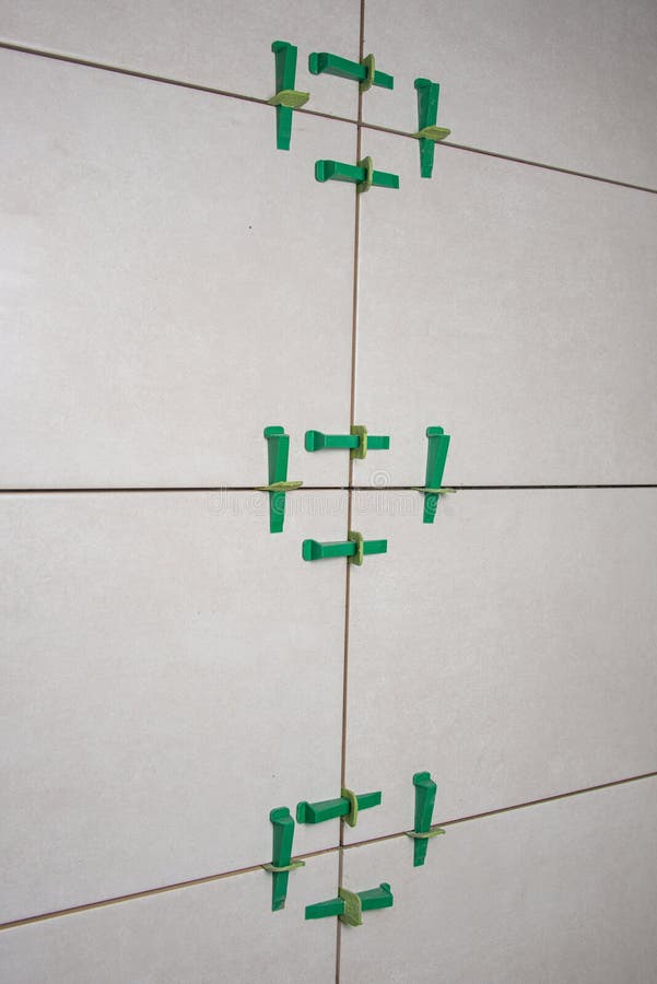 Tile Leveling System with Plastic Clips and Wedges, Shot while the Tile ...