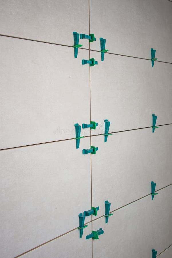 Tile Leveling System with Plastic Clips and Wedges, Shot while the Tile ...