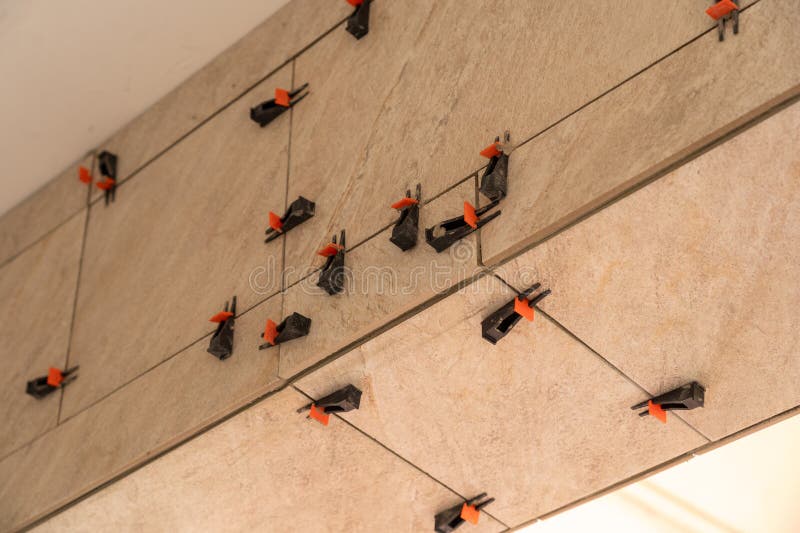 Tile Leveling System with Plastic Clips and Wedges, Shot while the Tile ...