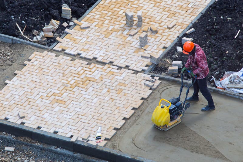 The Tiler Compacts the Soil with a Vibrating Plate before Laying Paving ...