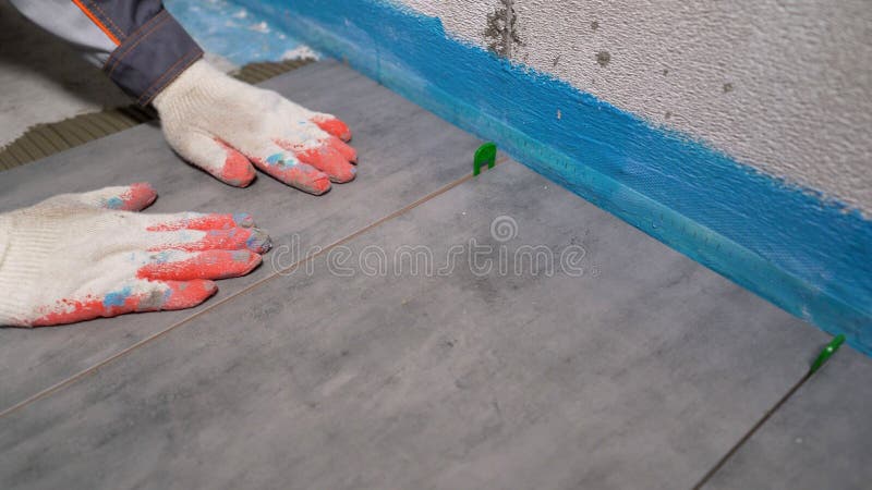 Construction Worker Placing Gray Tiles on Floor Using Tile Leveling ...