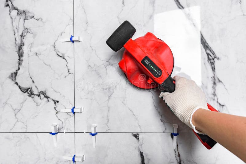 Tiler Laying Tiles Using Electric Vibrating Suction Cup. Stock Photo ...