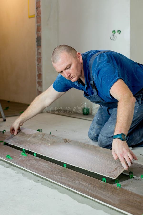 Tiler Placing Ceramic Wall Tile in Position Over Adhesive with Lash ...