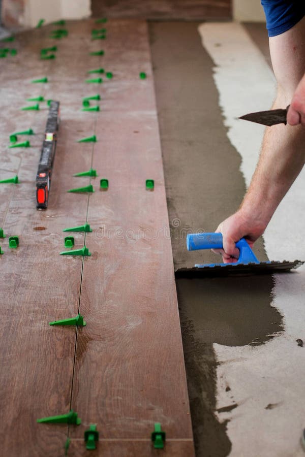 Tiler Placing Ceramic Wall Tile in Position Over Adhesive with Lash ...