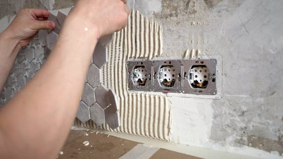Tiler Placing Hexagonal Tiles on Wall Around Electrical Outlets Stock ...