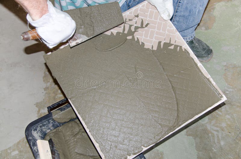 Tiler Spreading Tile Adhesive on the Back of a Tile Stock Photo - Image ...