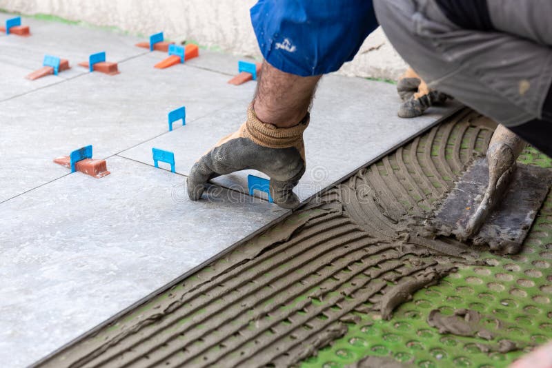 Tiler at Work Installing New Floor with Tiles. Construction Stock Image ...