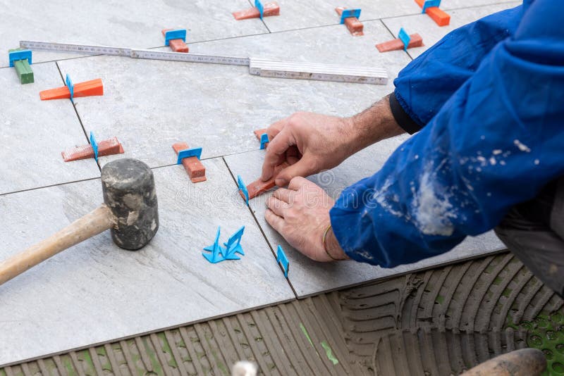 Tiler at Work Installing New Floor with Tiles. Construction Stock Photo ...
