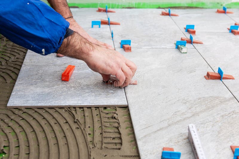 Tiler at Work Installing New Floor with Tiles. Construction Stock Image ...