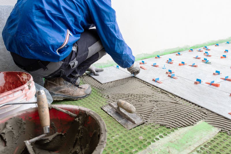 Tiler at Work Installing New Floor with Tiles. Construction Stock Image ...