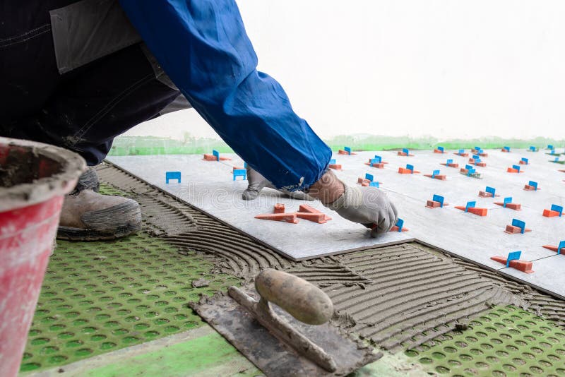 Tiler at Work Installing New Floor with Tiles. Construction Stock Image ...