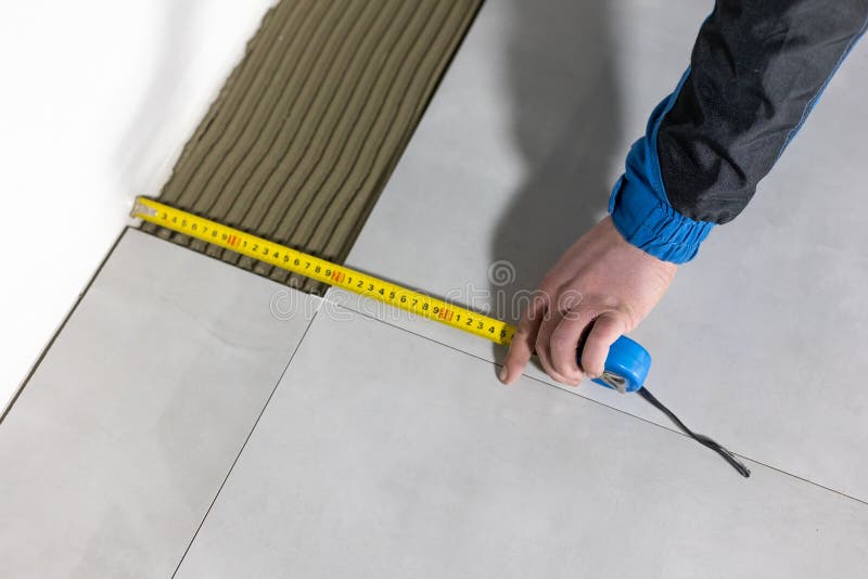Tiler Worker Placing or Tiling Gray Ceramic Tile in the Position Over ...